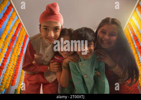 Kids in Tradional clothes looking down at the Camera during Diwali ...