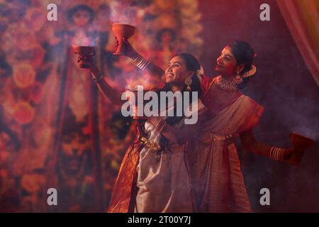Bengali women performing dhunuchi dance on the occasion of Durga Puja ...