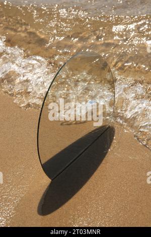 Round mirror reflecting sea on sandy beach Stock Photo - Alamy