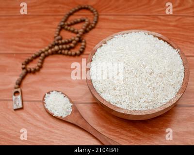 holy Quran and a grain of rice in a wooden bowl. Islamic zakat concept ...