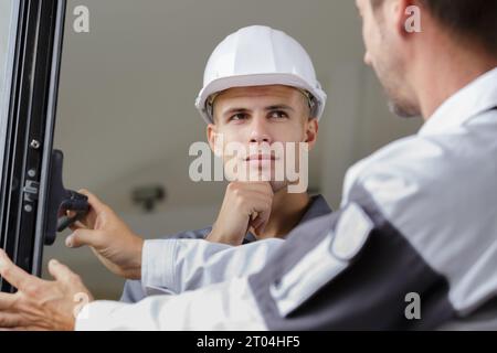 concentrated apprentice builder installing a window Stock Photo - Alamy