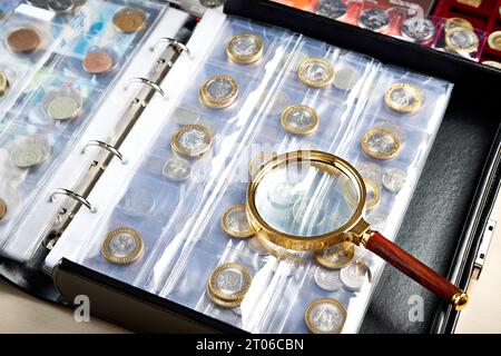 Collecting coins numismatics. Album with magnifying glass Stock Photo ...