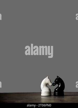 Vintage chess pieces, black and white knight on dark gray background ...