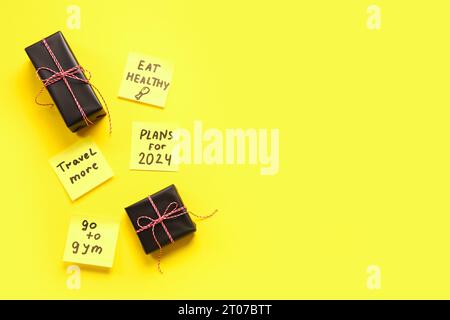 Sticky notes with goals for 2024, gift boxes and Christmas decorations ...