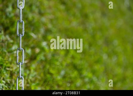 steel non-rusty chain on grass background, frame Stock Photo - Alamy