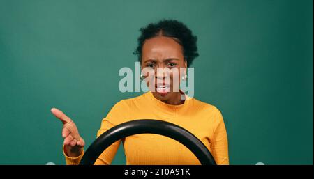 Young woman experiences road rage, angry while driving, green studio ...