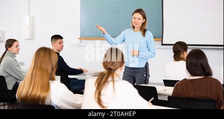 Positive adult female teacher leading a lesson Stock Photo - Alamy