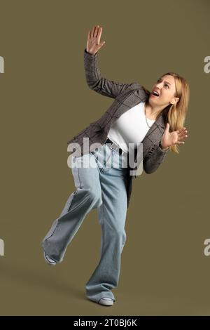 Scared mature woman on green background Stock Photo - Alamy