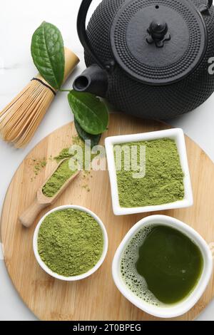 Flat lay composition with green matcha powder on white marble table ...