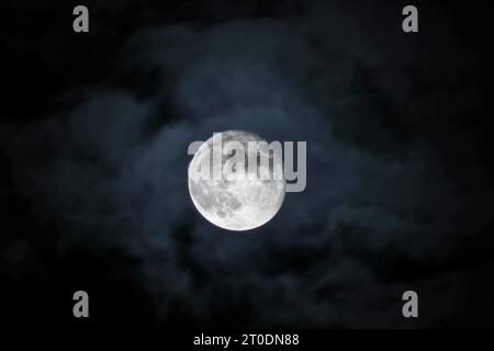 Cloud covered nearly full moon Stock Photo - Alamy