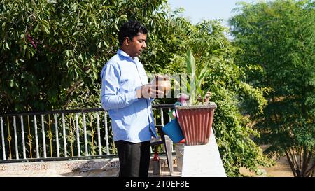 Hindu devotee offering water or Ardhya to the sun God at home on ...