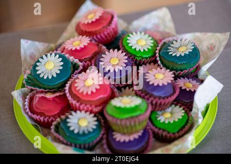 Muffins decorated with colorful flowers Stock Photo - Alamy