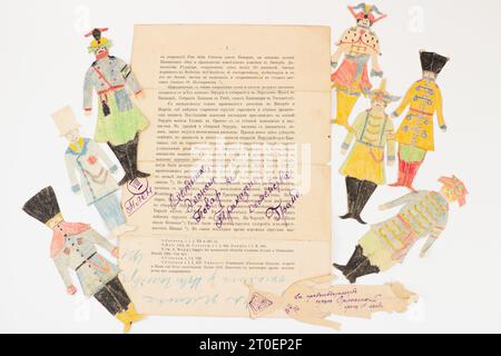 Handmade figures for childish play cut out from paper put in book page ...