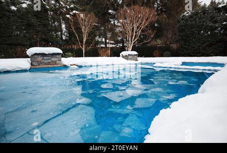 Pool with ice and slush after snow storm. Inground pool with pool cover ...