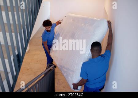 Mattress Removal And Delivery. Movers People Delivery Wrapped Mattress Stock Photo Alamy