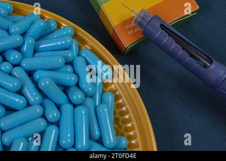 Yellow plate filled with blue medicine capsules representing drug ...