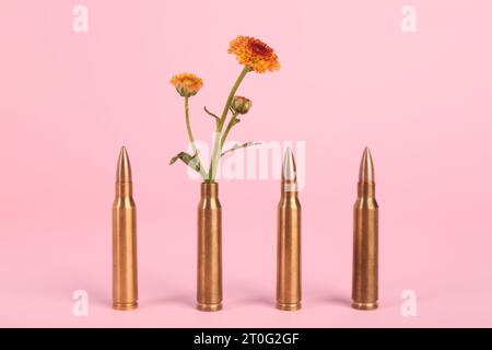 Bullets and beautiful flowers on pink background, flat lay. Banner ...