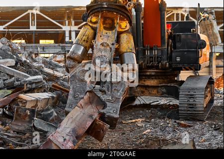Hydraulic breaking shears cut through the steel beam. Demolition of ...