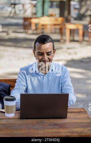 Handsome latin man working using computer laptop smiling positive doing ...