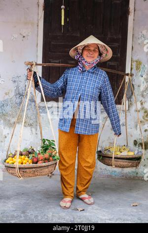 Vietnamese woman carrying produce on a bamboo yoke, Hoi An (UNESCO ...
