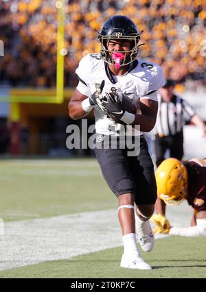 Colorado running back Dylan Edwards, left, fends off UCLA linebacker ...