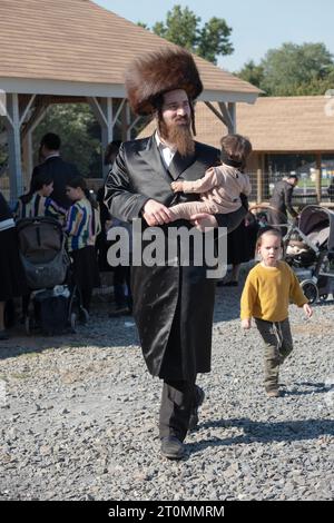 A Hasidic father with long curly peyot & wearing a shtreimel fur hat ...
