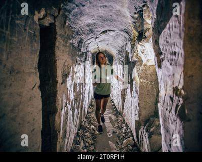 Female digger with flashlight explores the tunnel Stock Photo - Alamy
