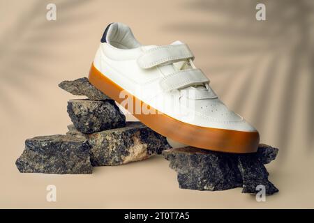 New sneaker shoe on stones on beige studio background Stock Photo - Alamy