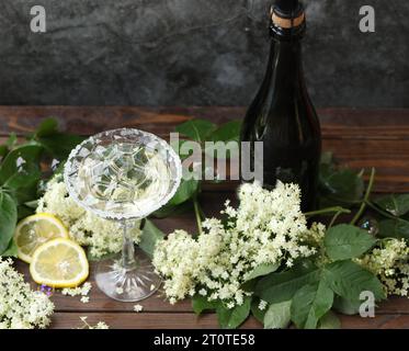 Glass of champagne with elderflower liqueur. Decorated with white elder ...