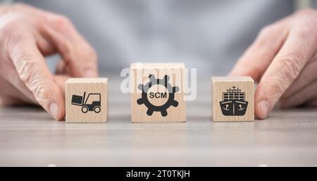 Wooden blocks with symbol of scm concept on blue background Stock Photo ...