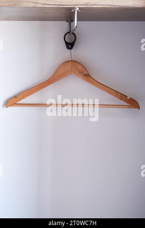 One empty wooden clothes hanger hanging in a closet Stock Photo - Alamy