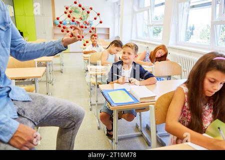 Male student with book and molecular model in library Stock Photo - Alamy