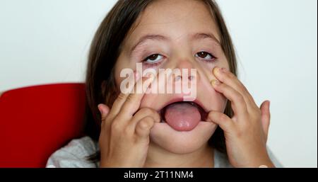 Little girl grimacing, sticking ongue out. Child grimace making funny ...