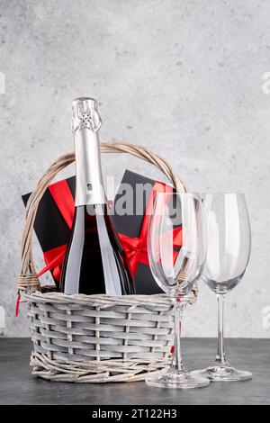 Basket with Christmas gift boxes, champagne, oranges and decor Stock ...