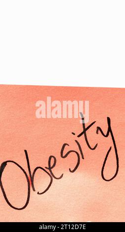 Obesity handwriting text close up isolated on orange paper with copy ...