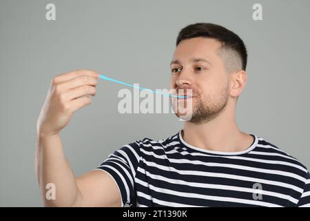 Handsome man chewing bubble gum on light grey background Stock Photo ...