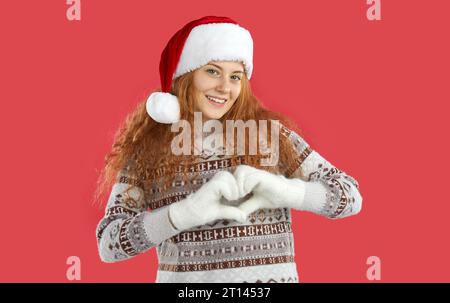 Beautiful redhead girl in santa hat open Christmas stocking and looking ...