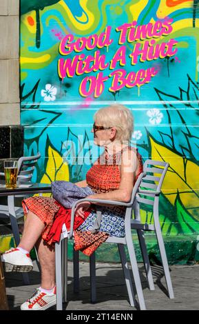 London,UK. Camden Town - elderly woman with a pint of beer sitting in ...