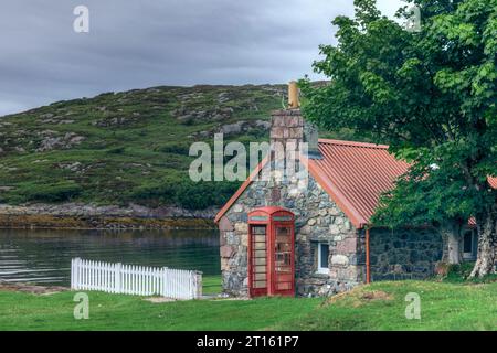 Red traditional phone booth at the edge of Loch Inver, Sutherland ...