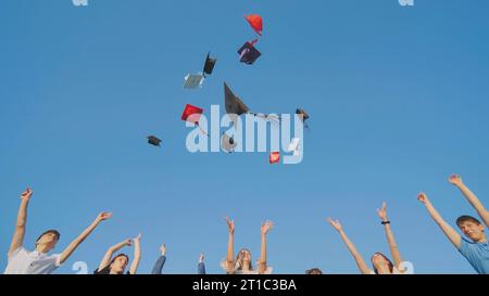 College graduates throw colorful hats up in the air Stock Photo - Alamy