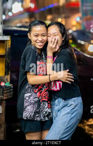Two young pretty Filipino girls pose and smile for their portrait in ...