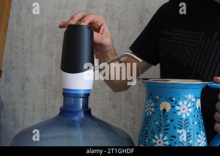 A person filling water. A person who fills water to drink. A person ...