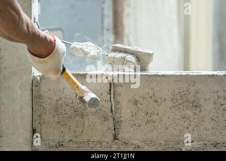 Hand of worker using hammer smashing and demolish on brick block wall ...