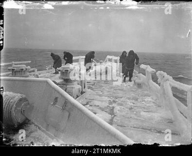 During convoy duty in Arctic waters, Royal Navy crew members clear the ...