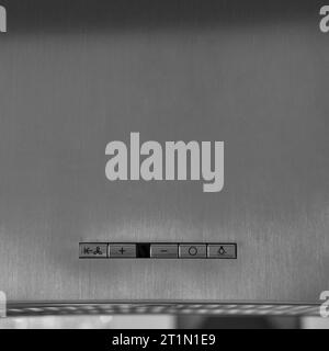 Extractor fan above hob in black granite island unit in modern openplan ...