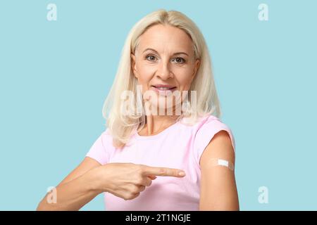 Mature woman with medical patch on arm against blue background ...