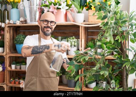 Young bald man florist using difusser working at flower shop Stock ...