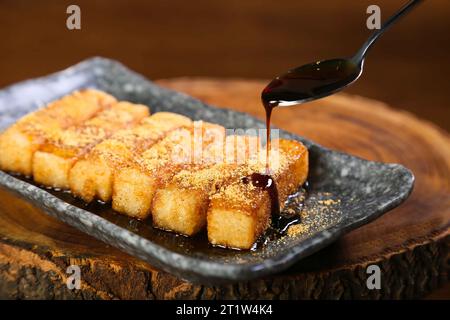 A plate of traditional Sichuan snacks, Brown sugar glutinous rice cake ...