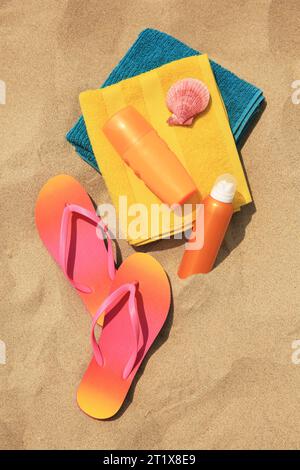 Flat lay composition with sunscreens on sand, space for text. Sun ...