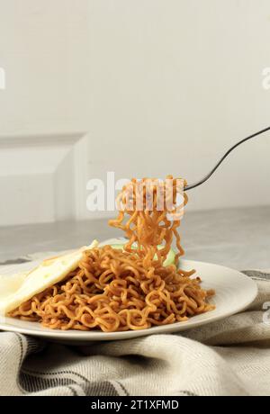 People eat the noodles with fork on wooden table background Stock Photo ...